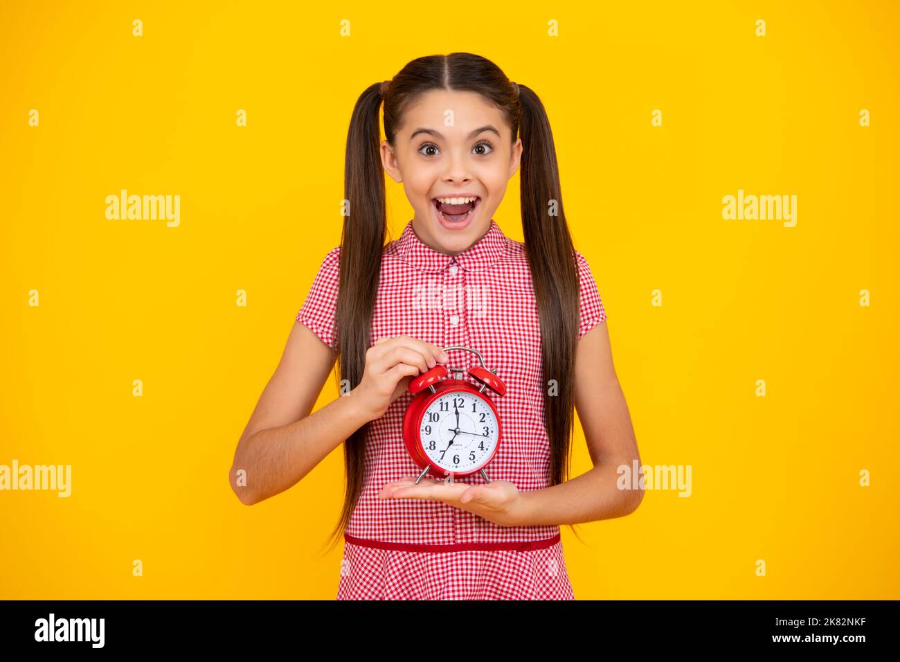 Portrait of teenage girl with clock alrm, time and deadline. Studio ...