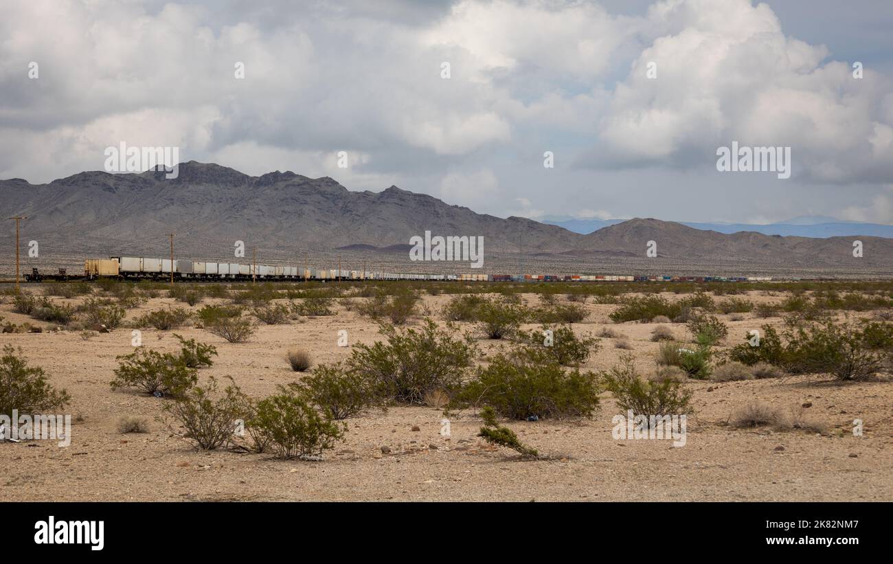 The train track with endless rows of wagons in the desert near the ...