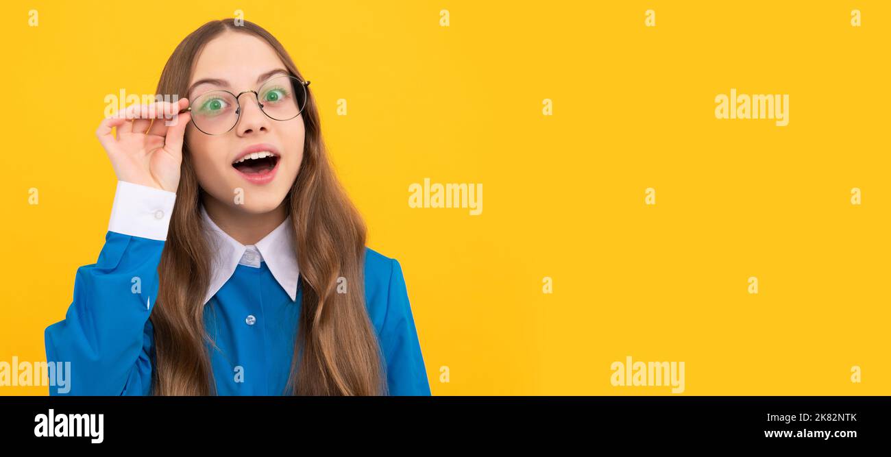 Curious school age girl child look through eyeglasses yellow background ...
