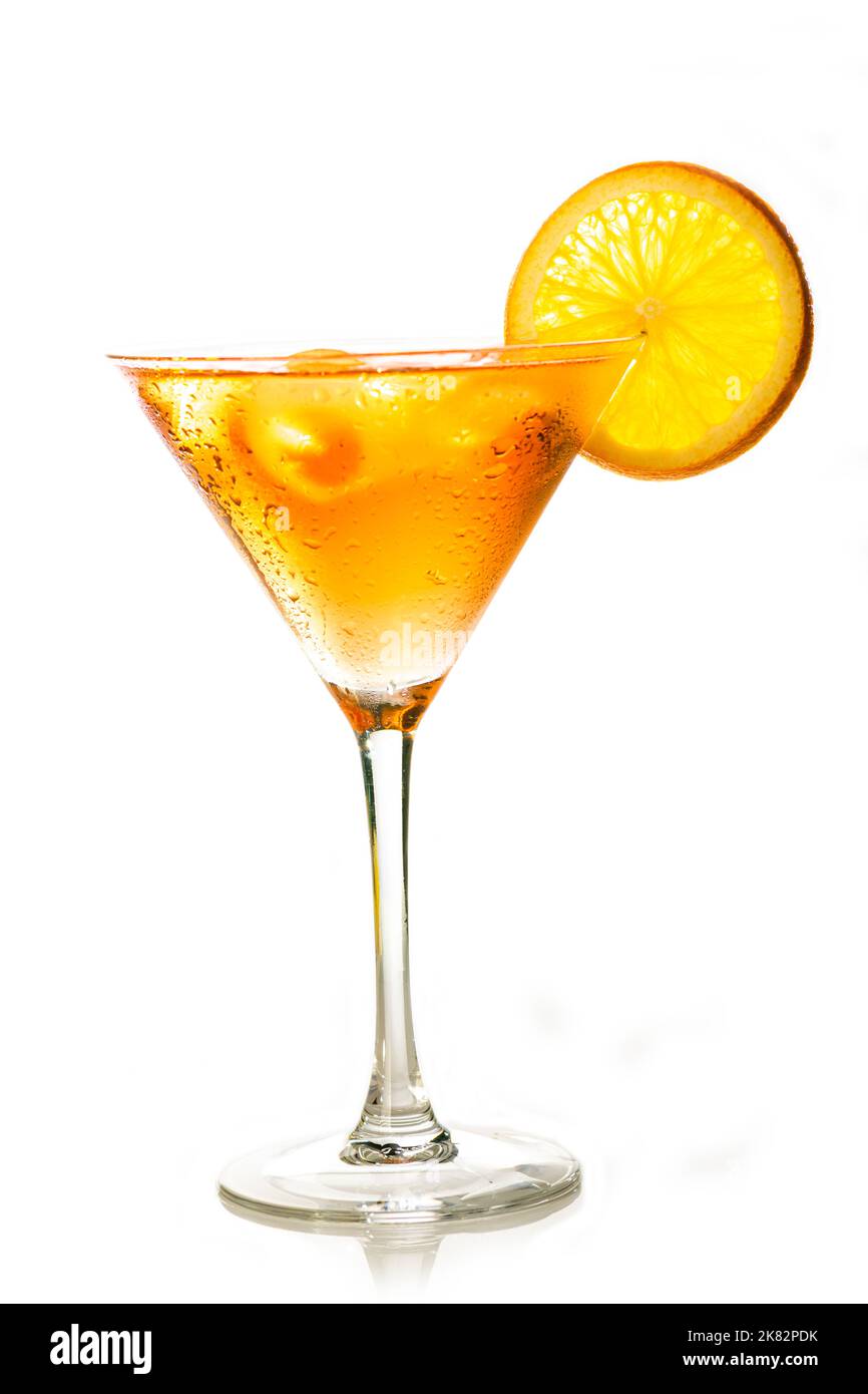 Yellow drink with ice cubes and orange slice on white background ...