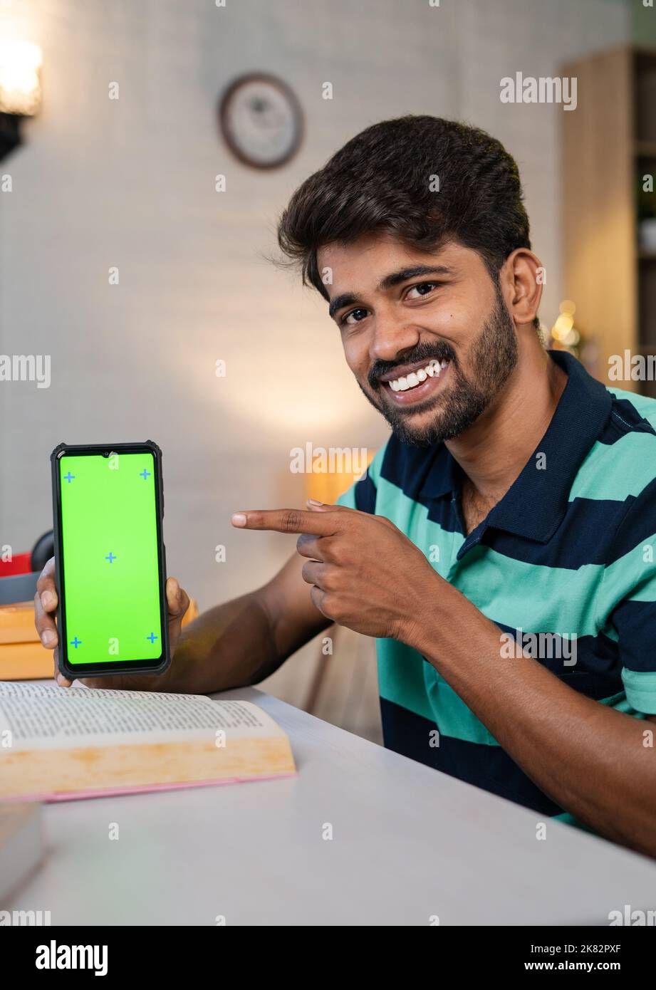 vertical shot of Happy smiling student at study table with books ...