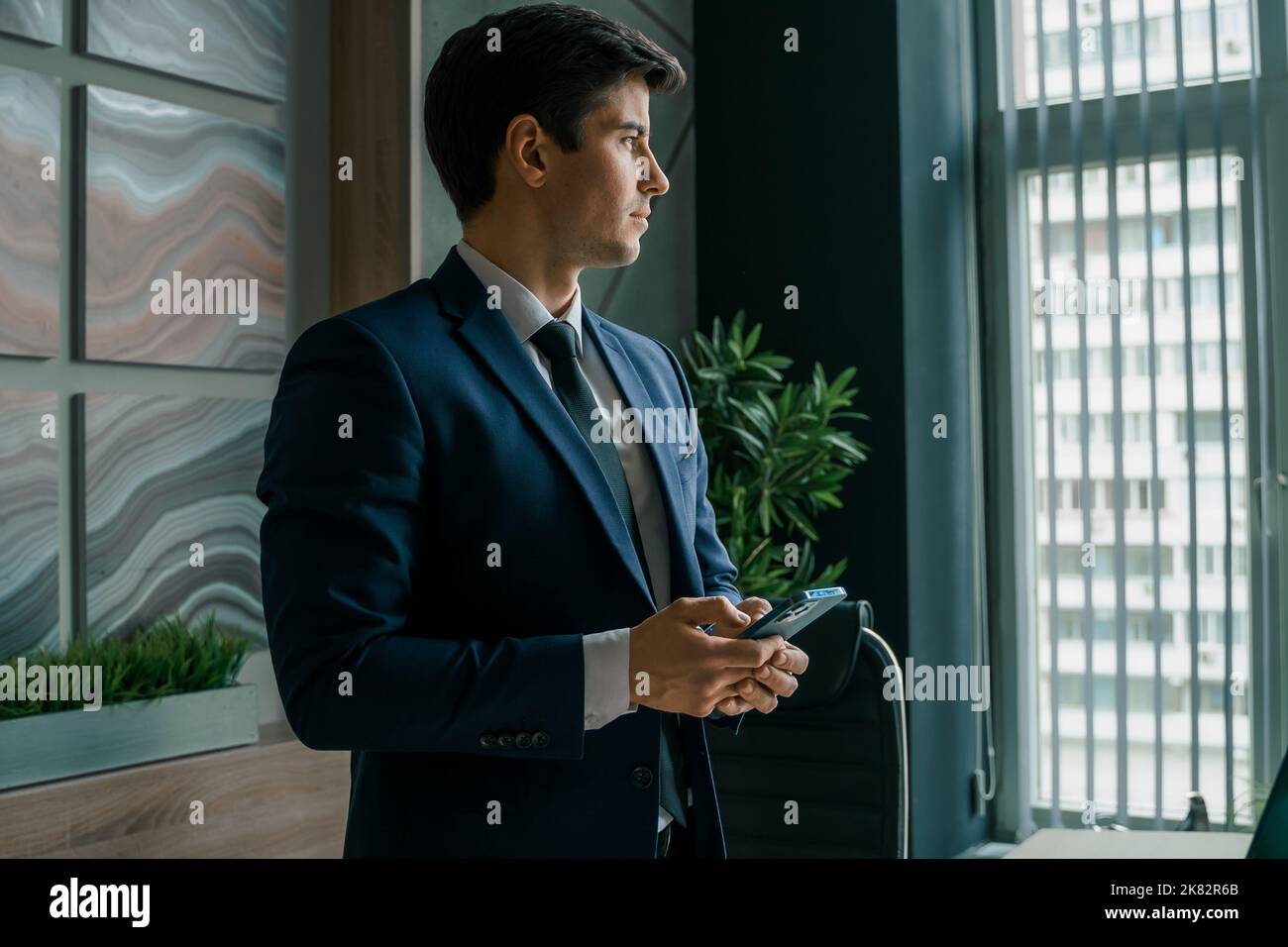 Businessman in suit with mobile phone in hands. Man typing message ...