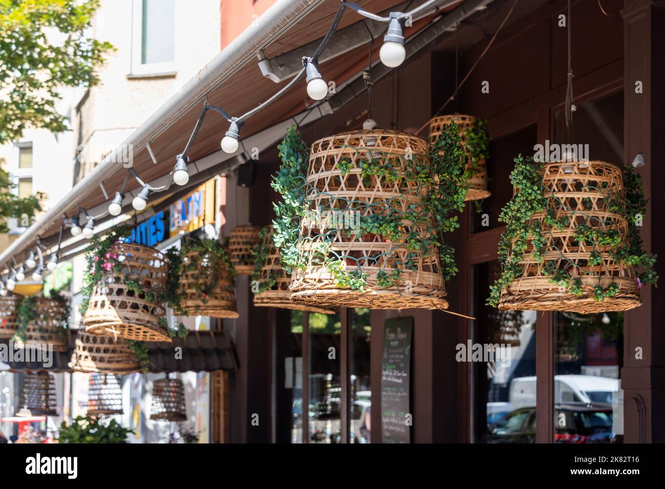 Wicker lampshades in an outdoor street cafe. Decorating hanging lantern ...