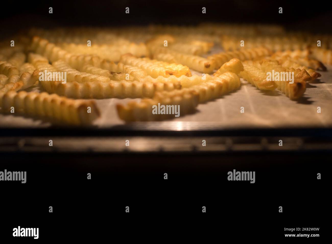 Closeup of Dutch fresh yellow fries baking in a hot oven. Preparing ...