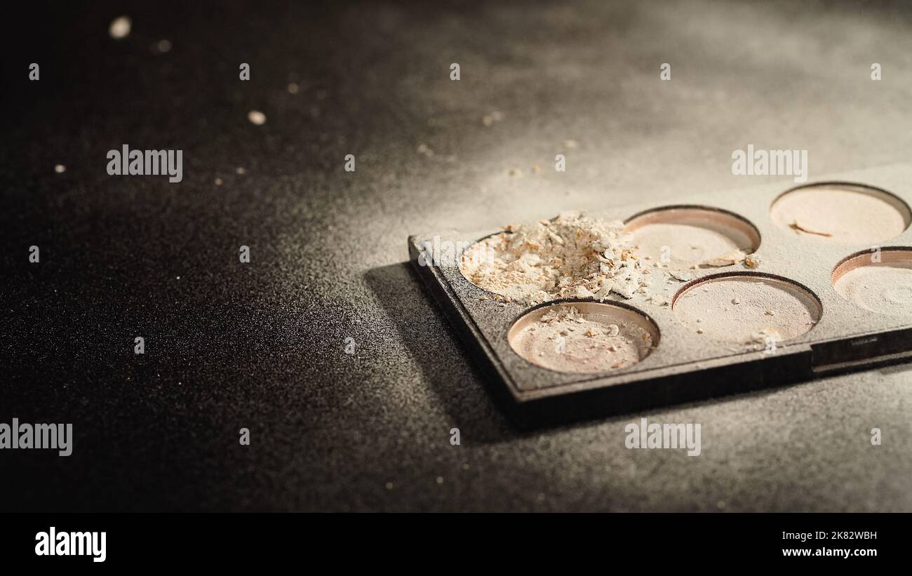 Close up view of palette with crushed face powder on black background ...