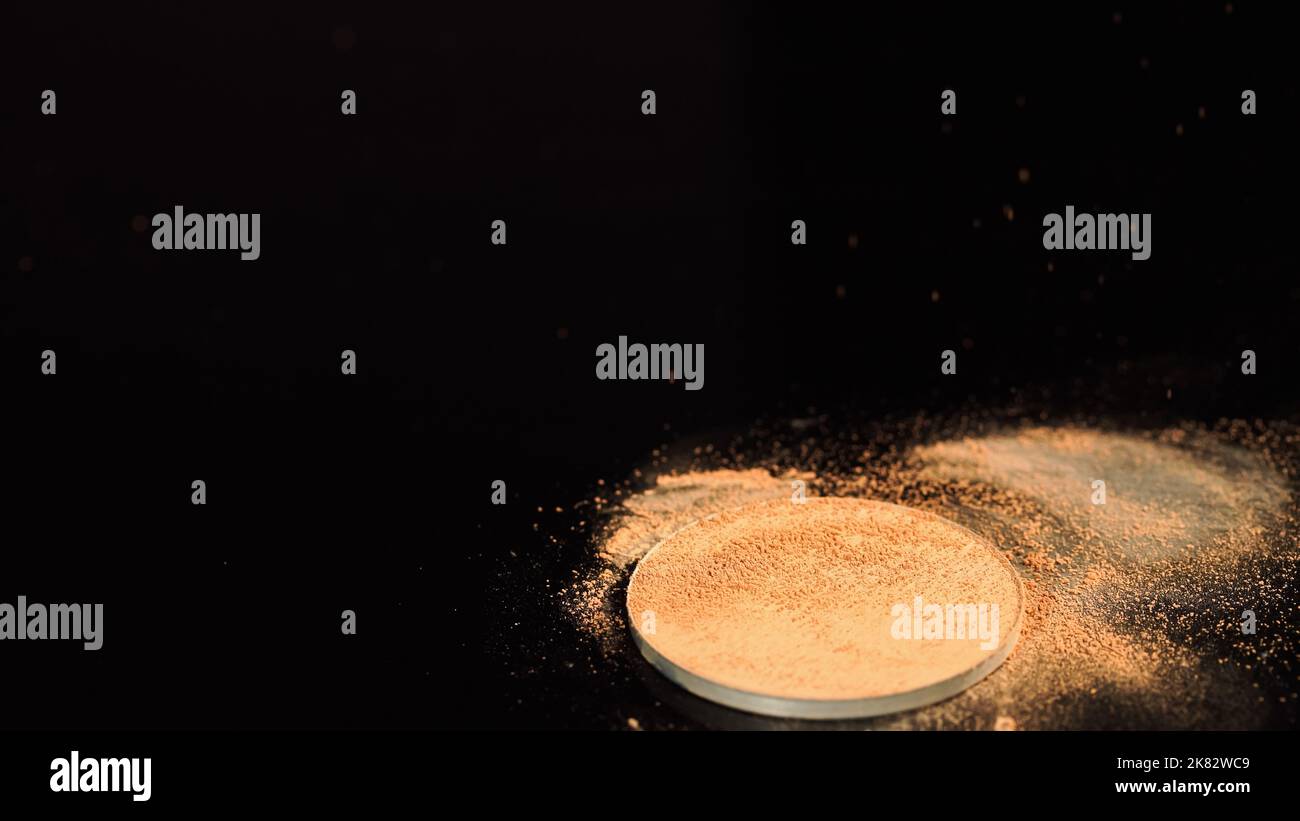 Close up view of beige face powder on black background with copy space ...