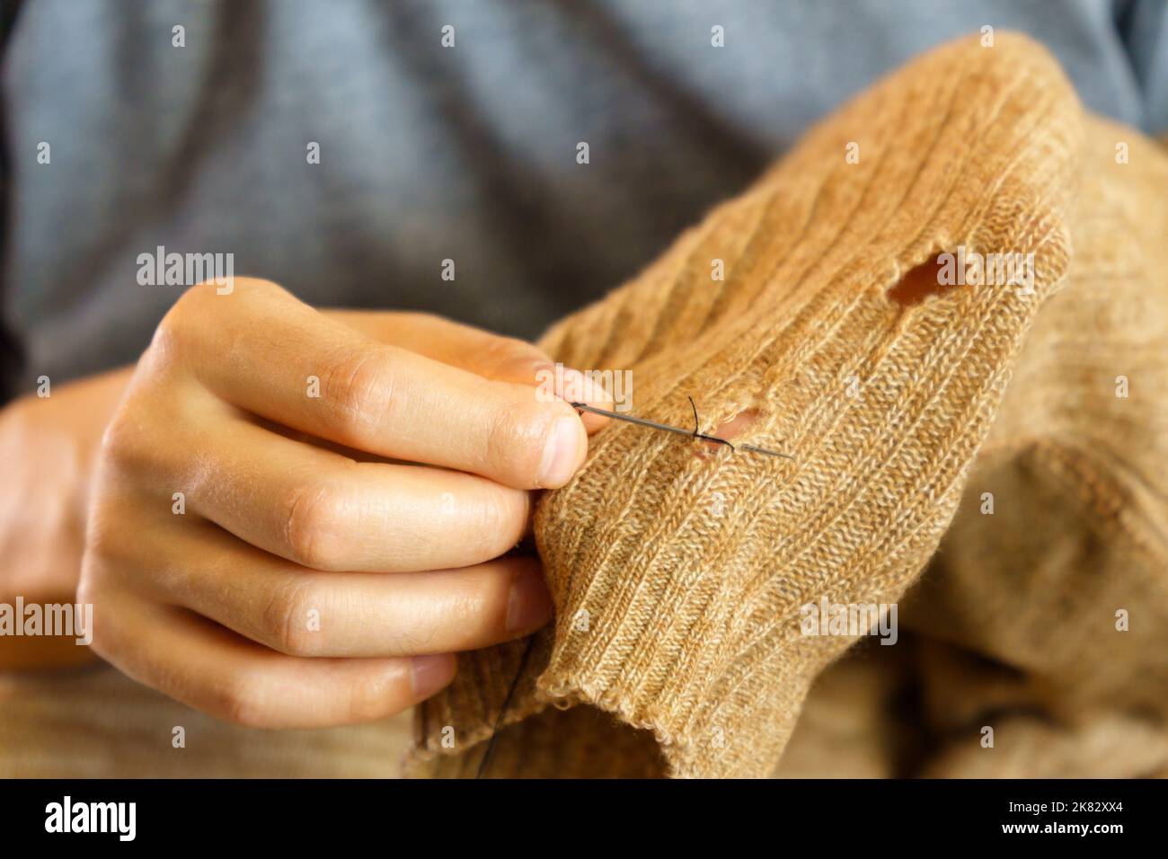 Mending clothes. Old worn woolen clothes. Repair concept, selective ...