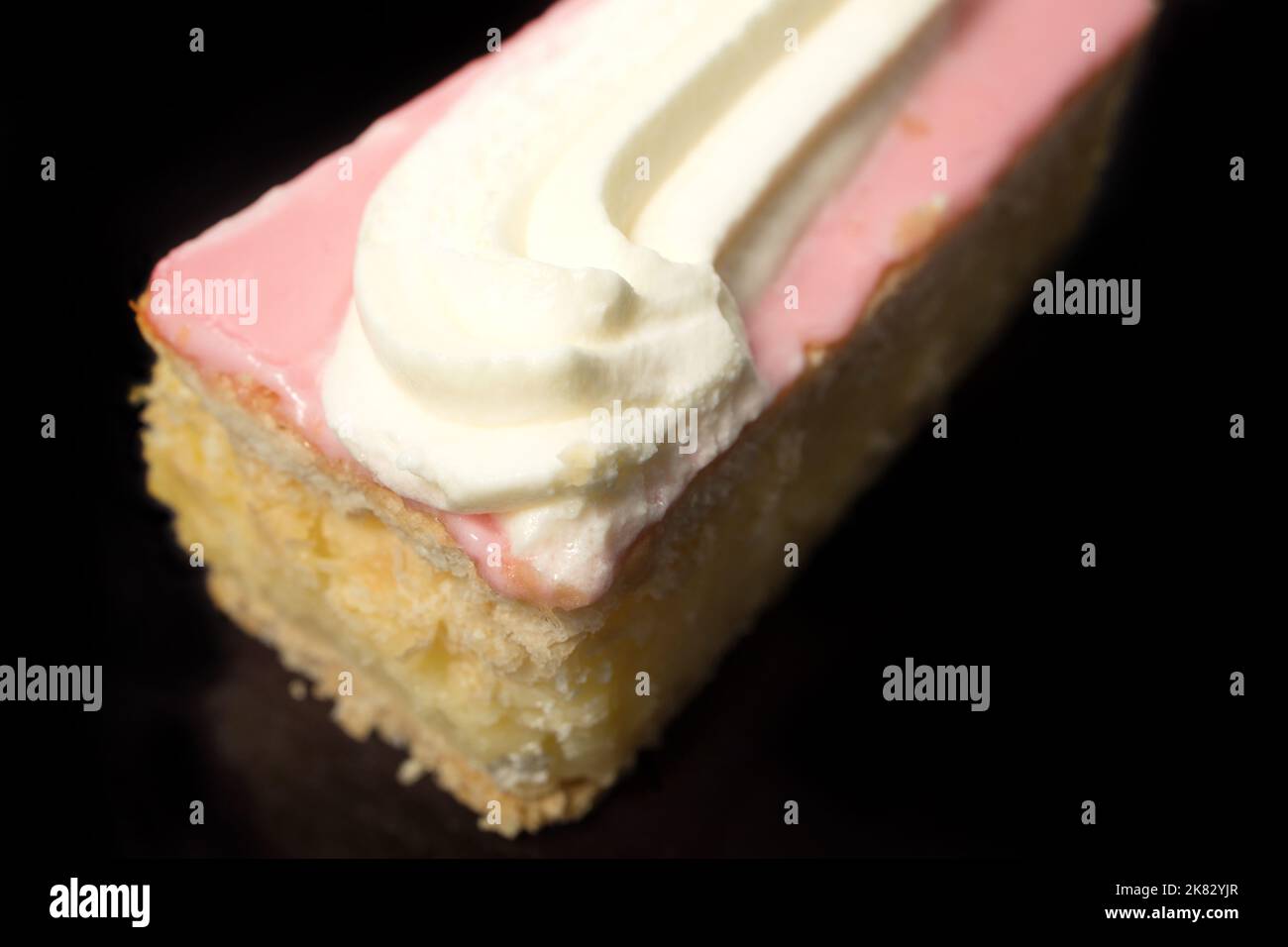 Closeup of dutch traditional pink Tompouce pastry filled with cream on ...