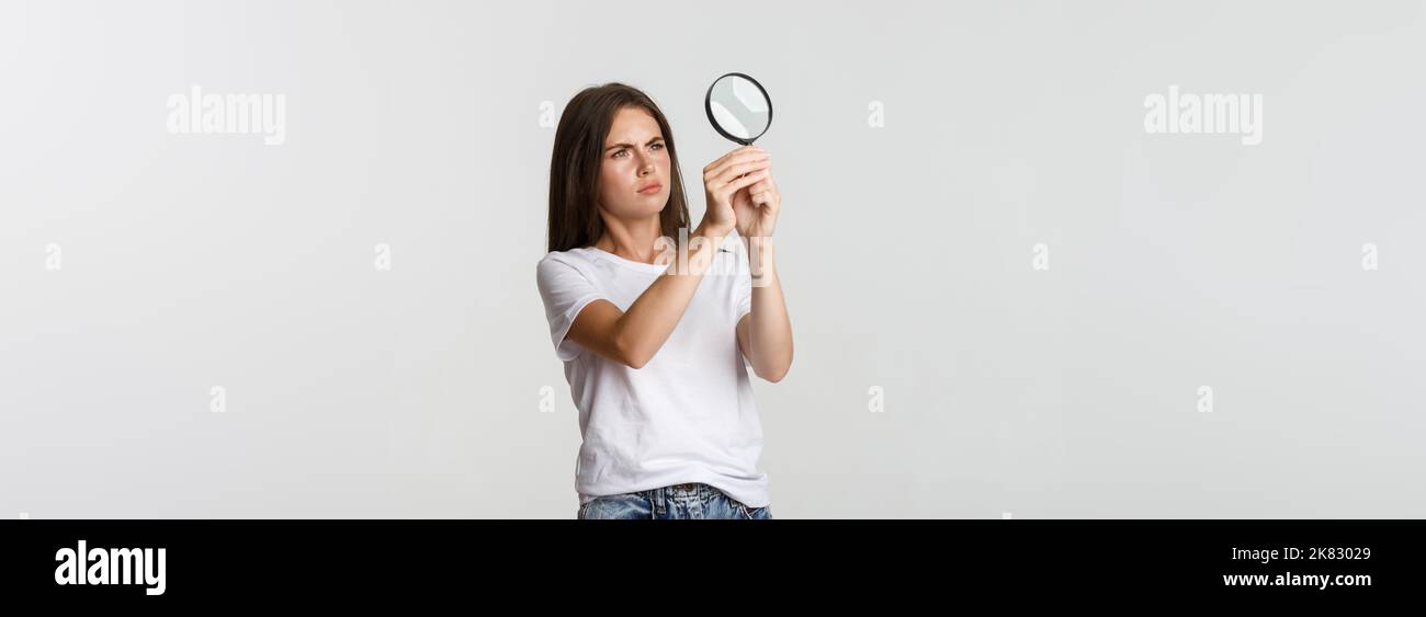 Serious-looking attractive young woman searching for something, looking ...