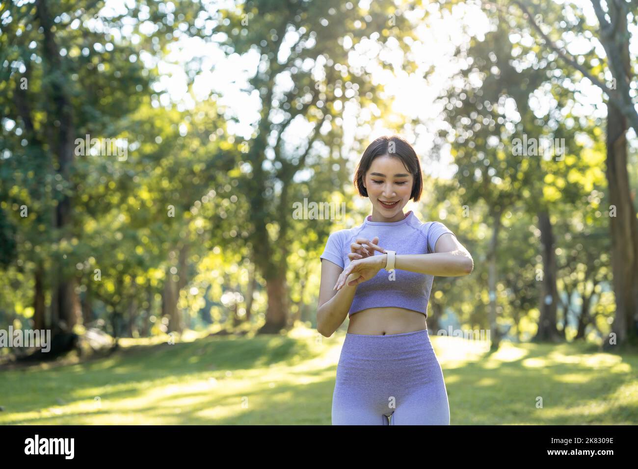 Young active sport woman using a smart watch to monitor her training ...