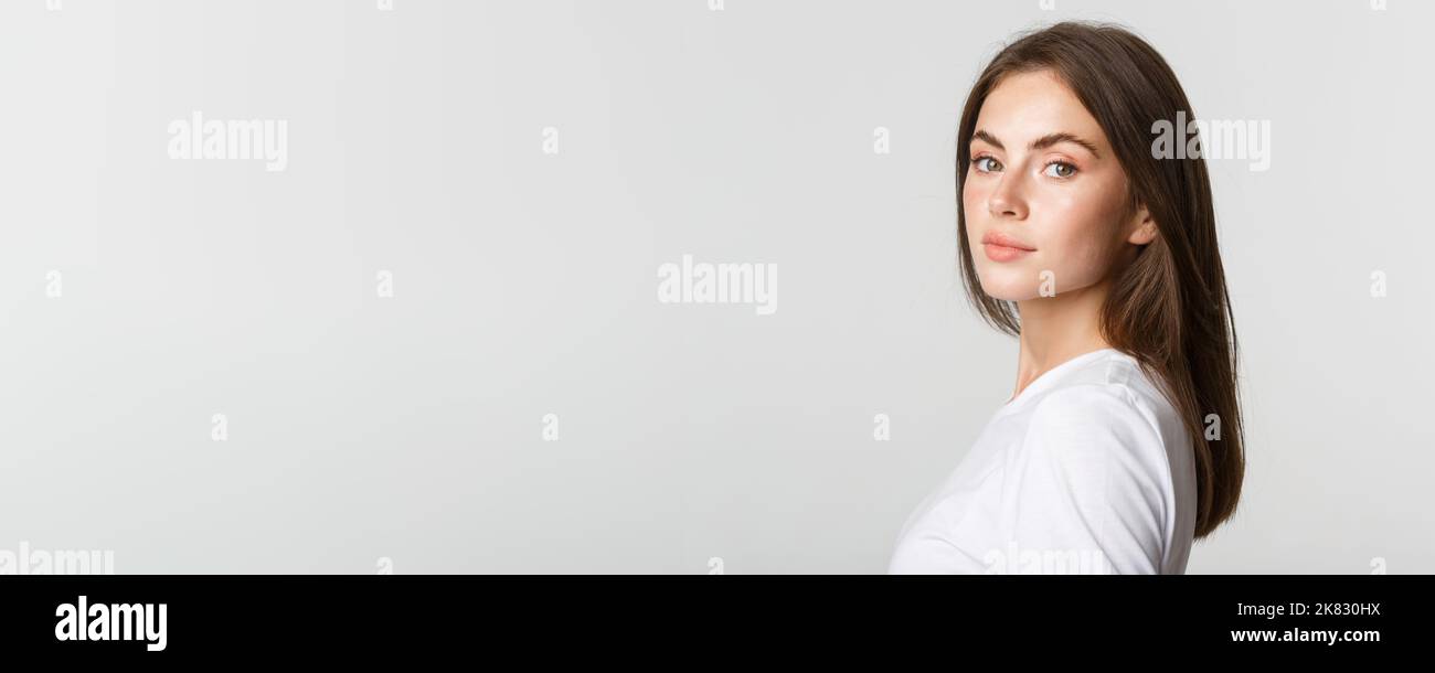 Portrait of confident beautiful brunette woman turning face at camera ...