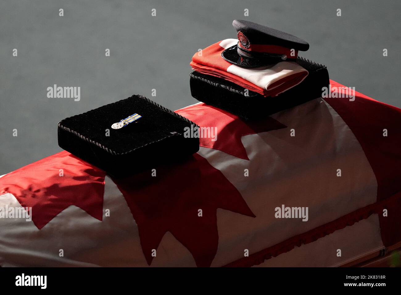 A medal, service cap and flags adorn the casket of South Simcoe Police ...