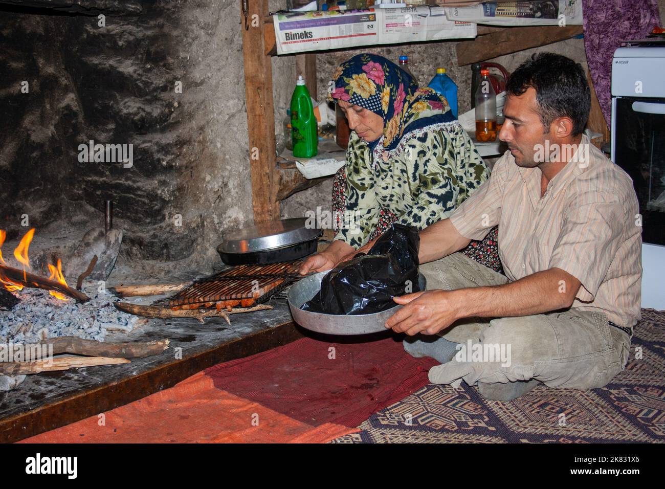 A rural family cooks a meal over coals in a country house in the Taurus ...