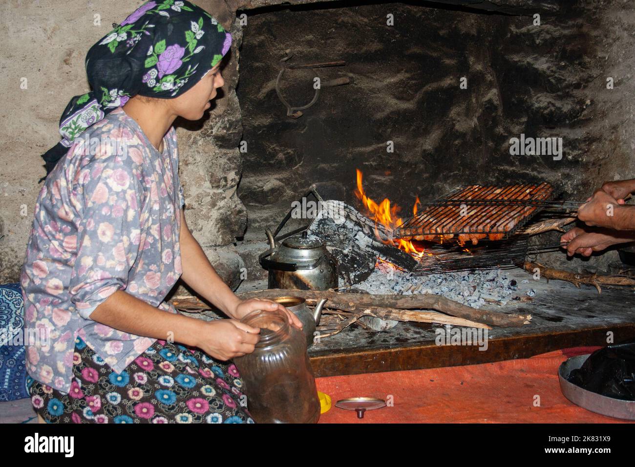 A Turkish woman cooks a meal over coals in a country house in the ...