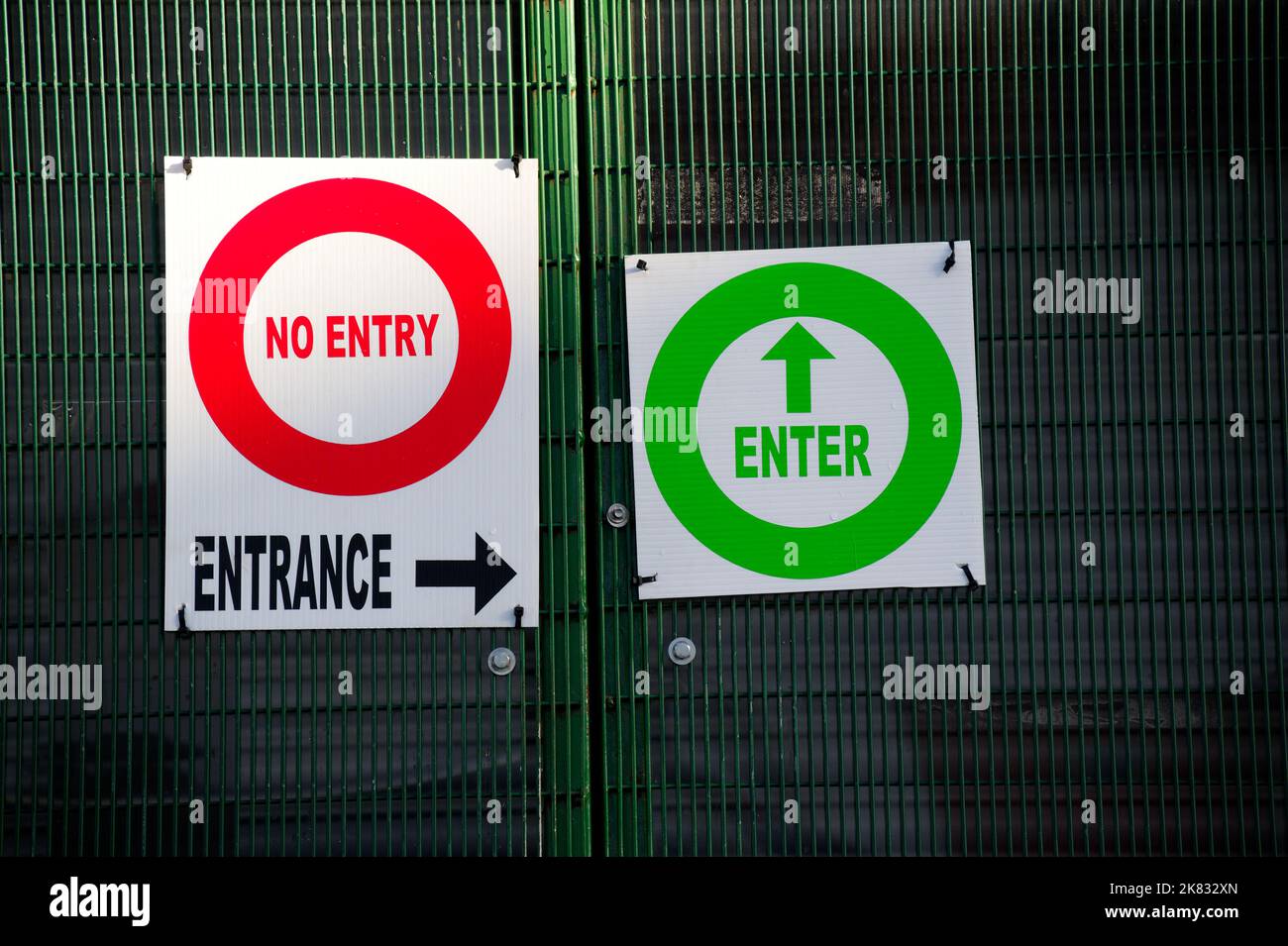 No entry and enter direction arrow sign at construction site entrance ...