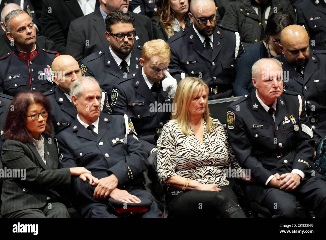 A police officer wipes away tears amid mourners during the join funeral ...