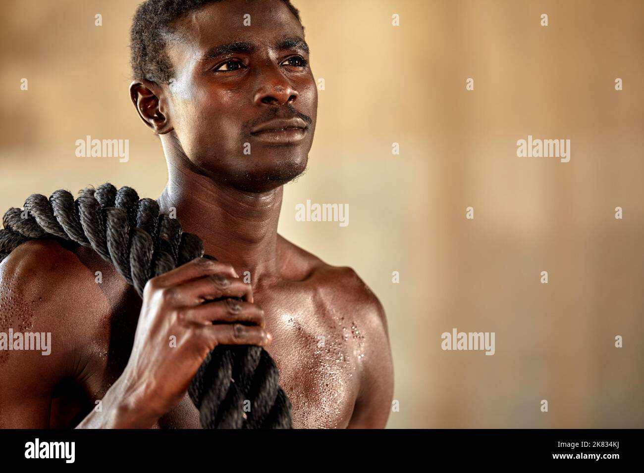 Rope workout. Sport man doing battle ropes exercise outdoor. Black male ...