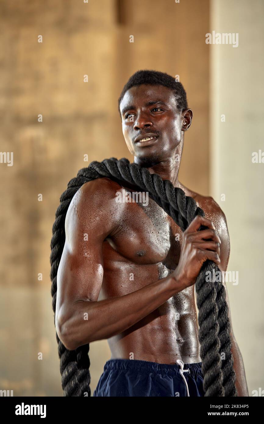 Rope workout. Sport man doing battle ropes exercise outdoor. Black male ...