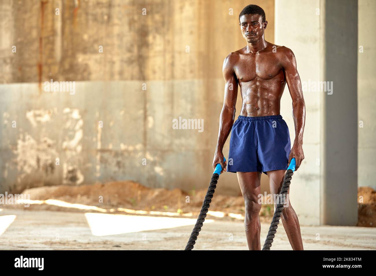 Rope workout. Sport man doing battle ropes exercise outdoor. Black male ...