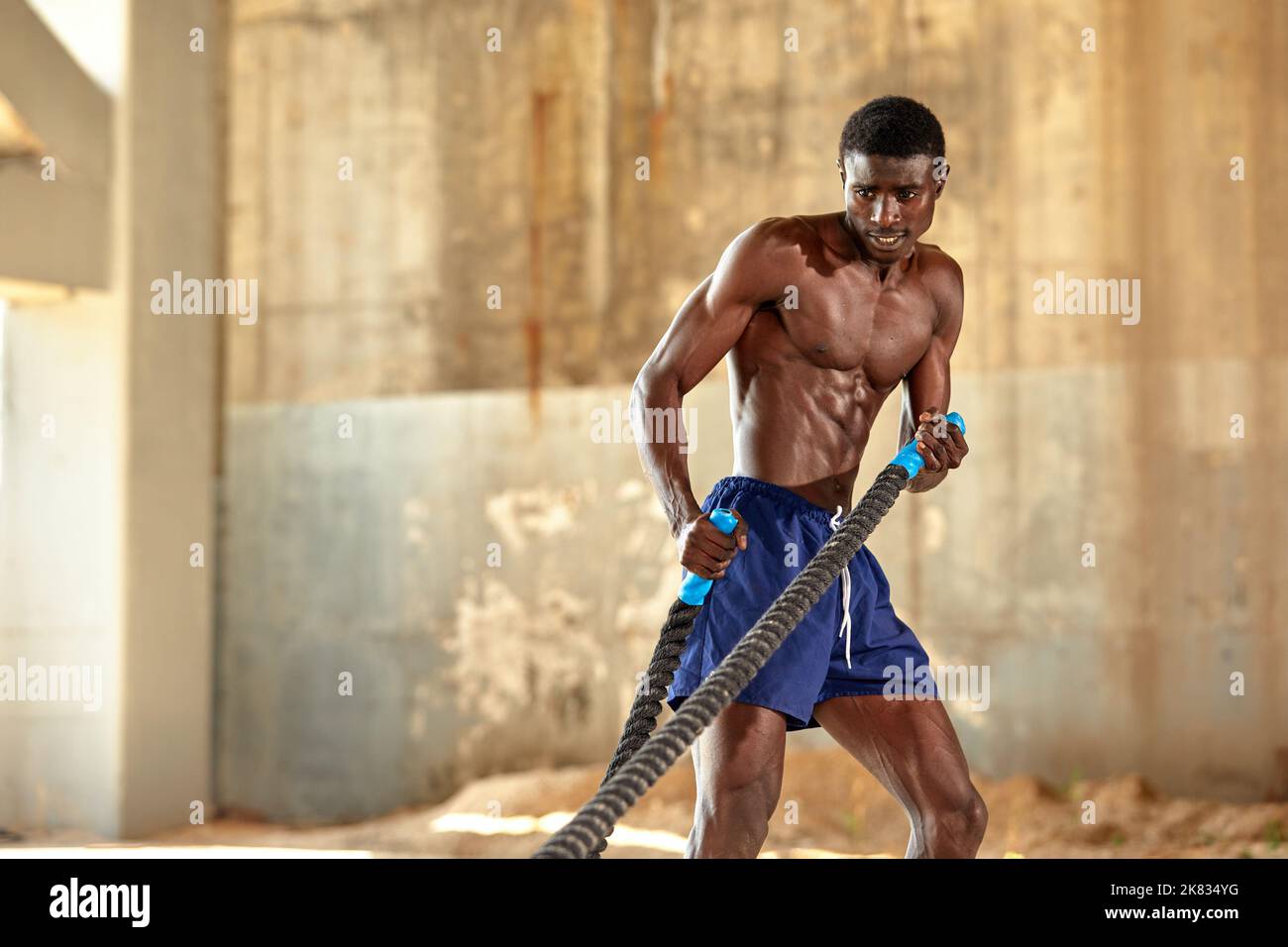 Rope workout. Sport man doing battle ropes exercise outdoor. Black male ...