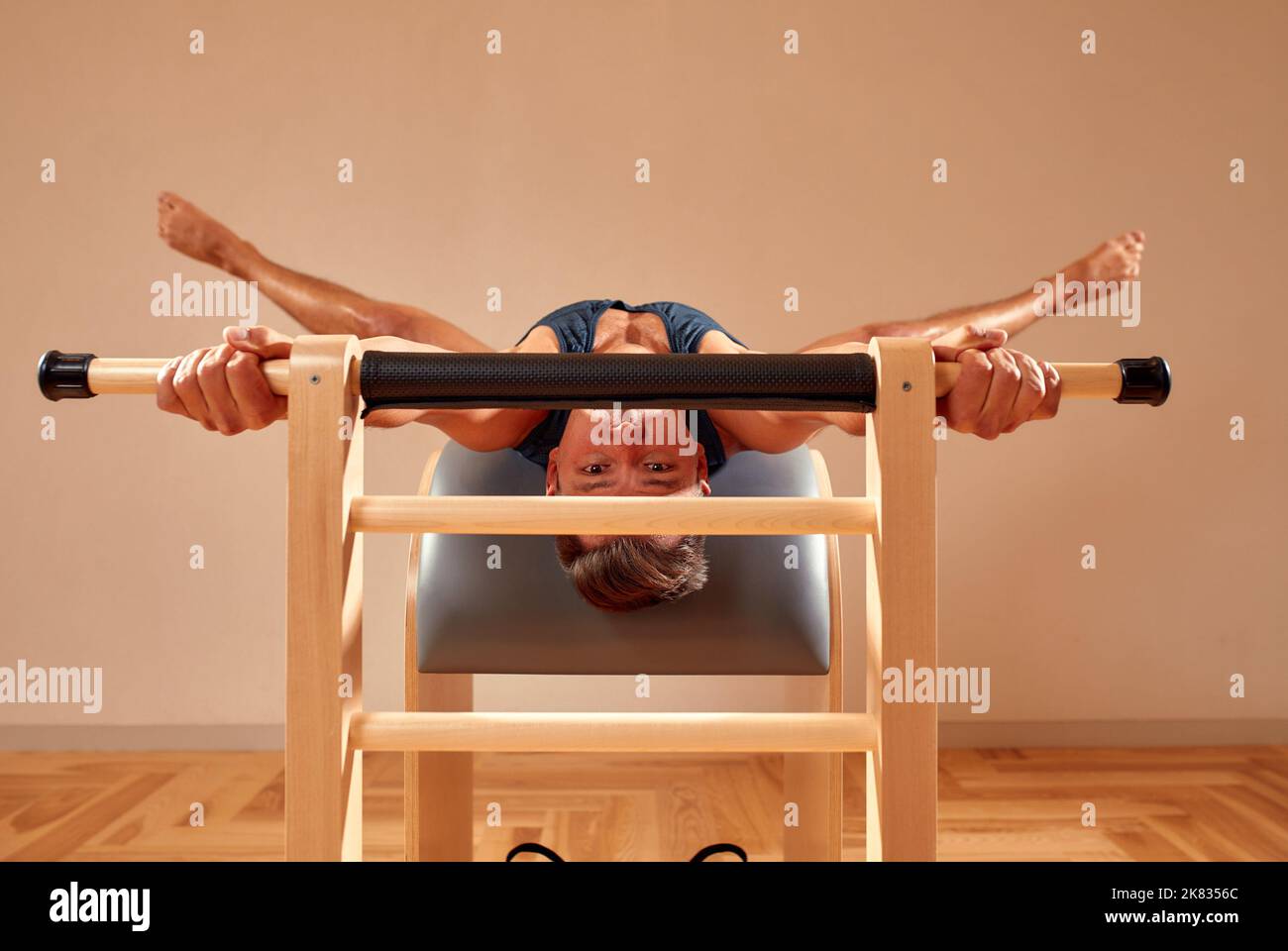 Handsome pilates male instructor performing stretching balance fitness ...