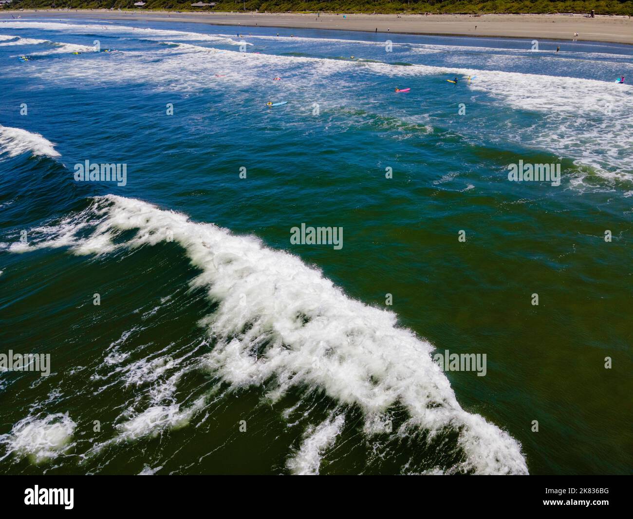 People learn to surf at Cox Beach, near Tofino on a beautiful summer ...