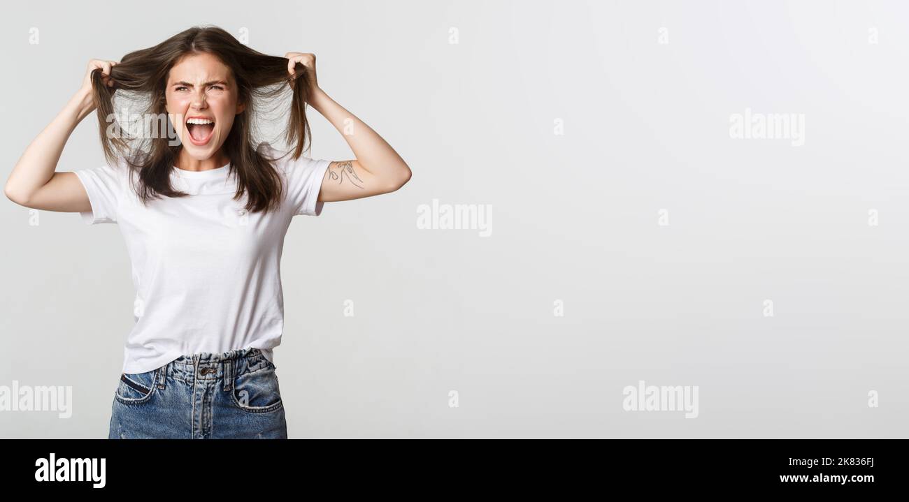 Outraged mad young woman ripping hair on head and yelling angry Stock ...