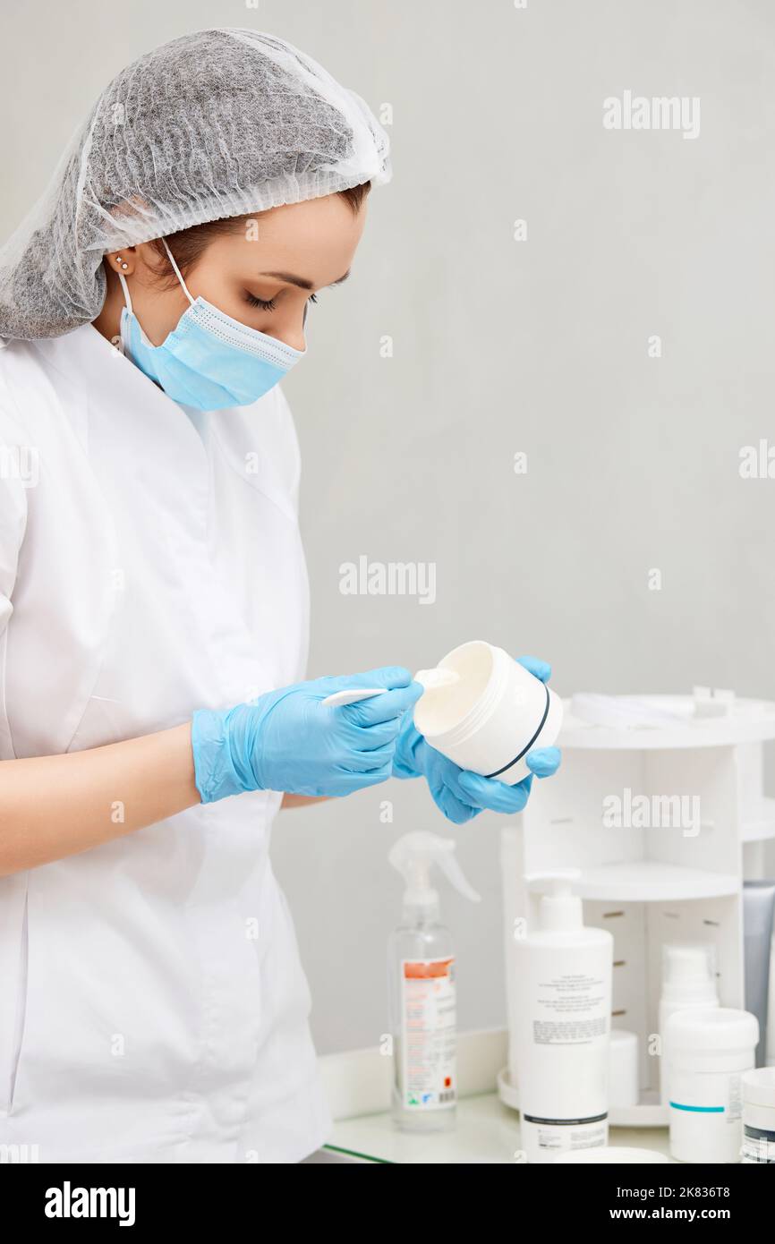 Beautician holding white plastic jar with cream Stock Photo - Alamy