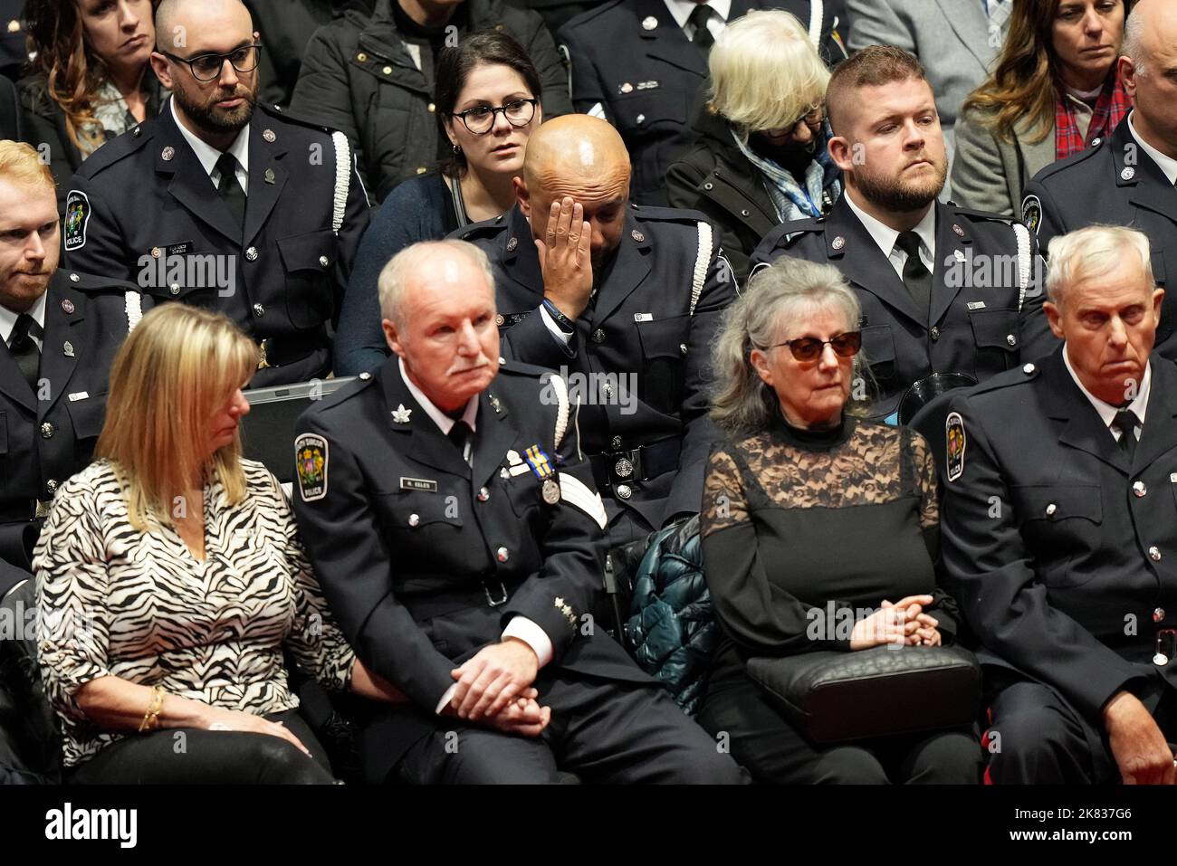 A police officer wipes away tears amid mourners during the join funeral ...