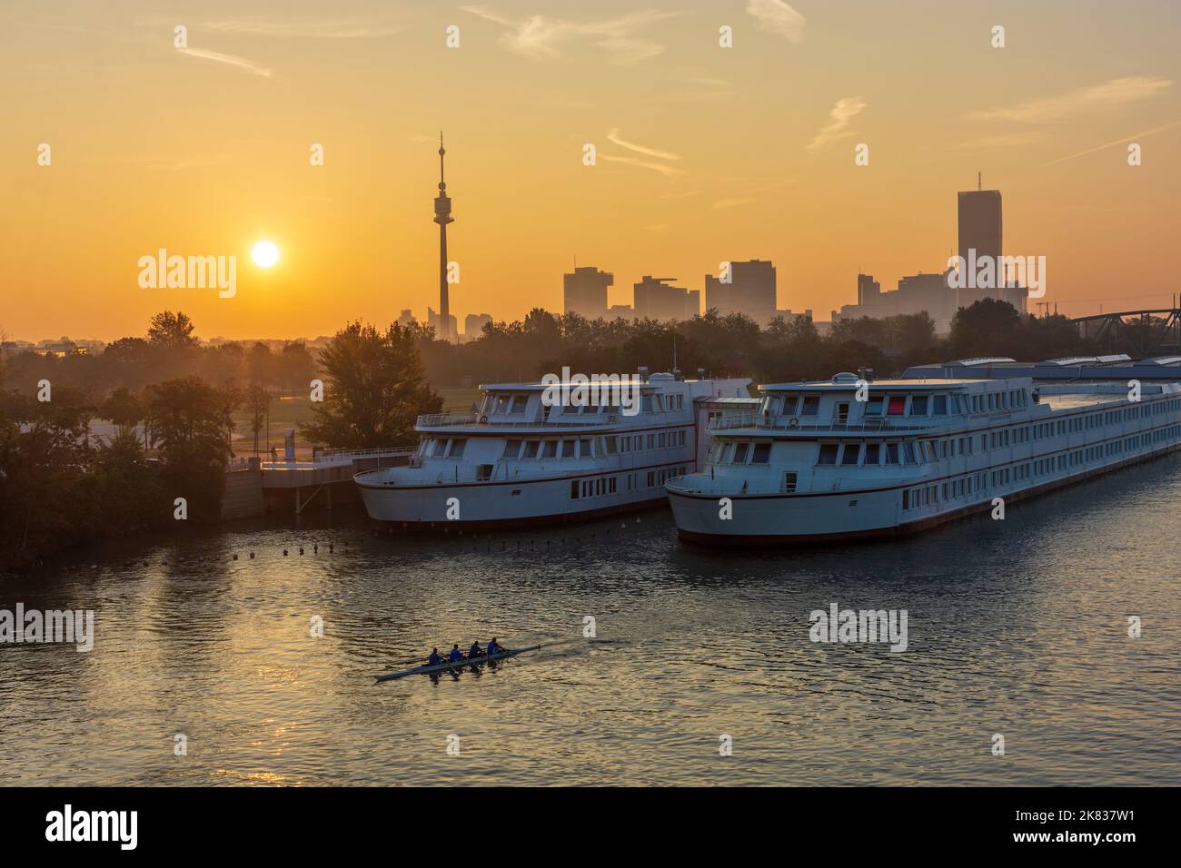 Rowing boat at sunrise at river donau danube hi-res stock photography ...