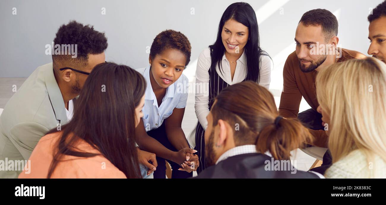 Group of happy young diverse people sitting in a circle and having a conversation Stock Photo ...