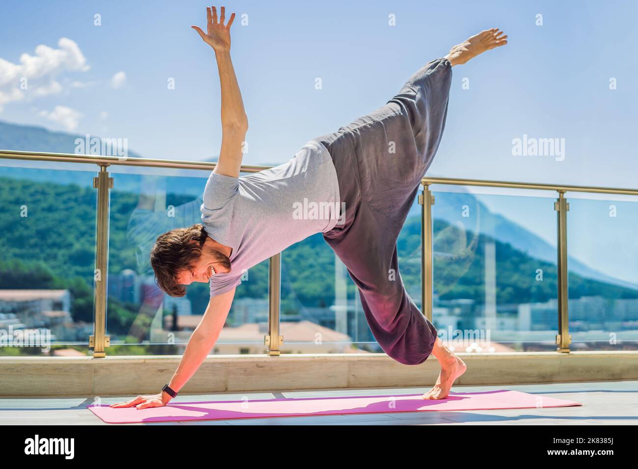 Man doing yoga outdoors on a rooftop terrace Stock Photo - Alamy