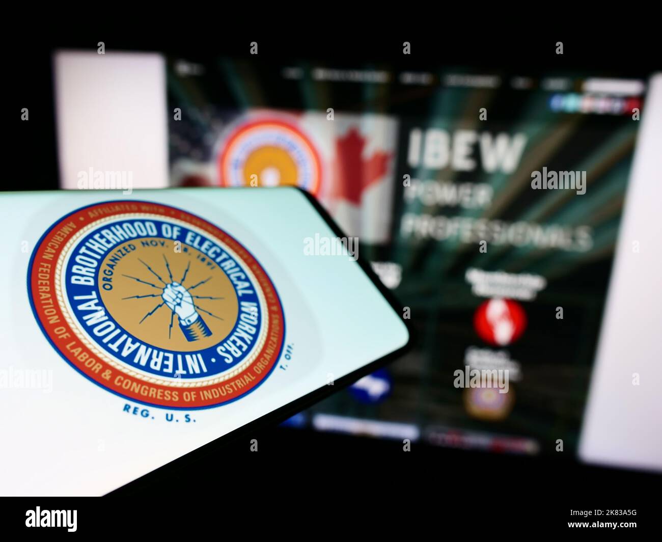 Mobile phone with logo of North American trade union IBEW on screen in ...