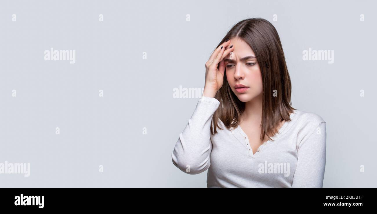 Woman touching her temples feeling stress, on gray background. Woman ...