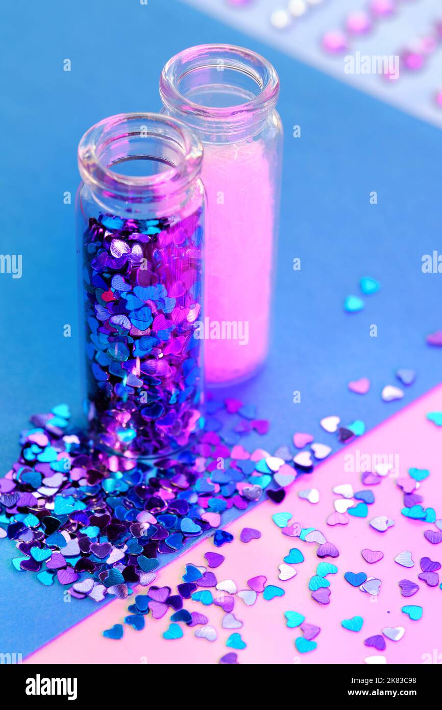 Neon colored powder glitter products on pink sparkling background ...