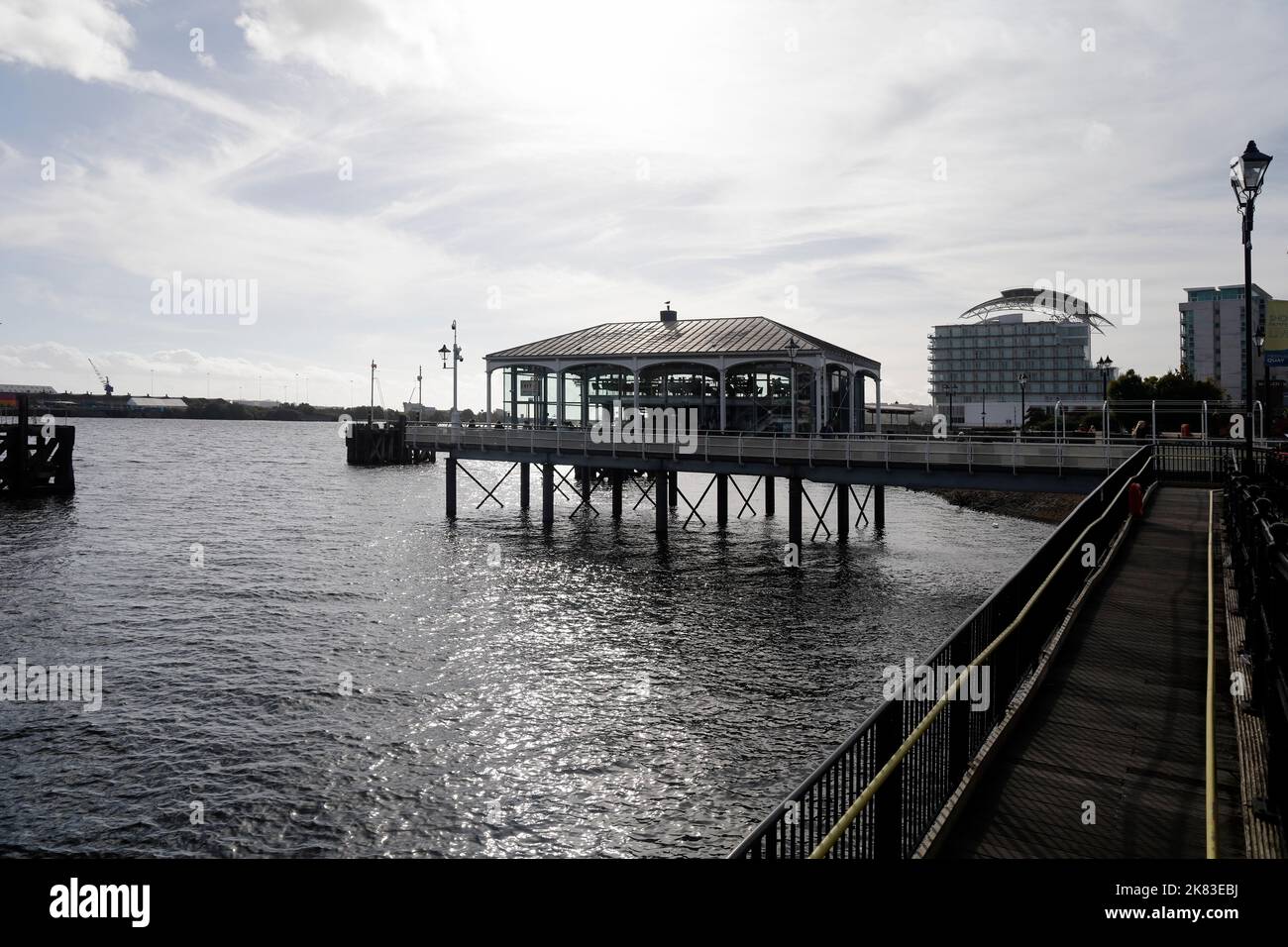 Contra jour shot of piers at Cardiff Bay waterfront with restaurants ...