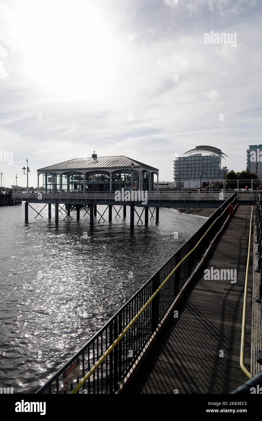 Contra jour shot of piers at Cardiff Bay waterfront with restaurants ...