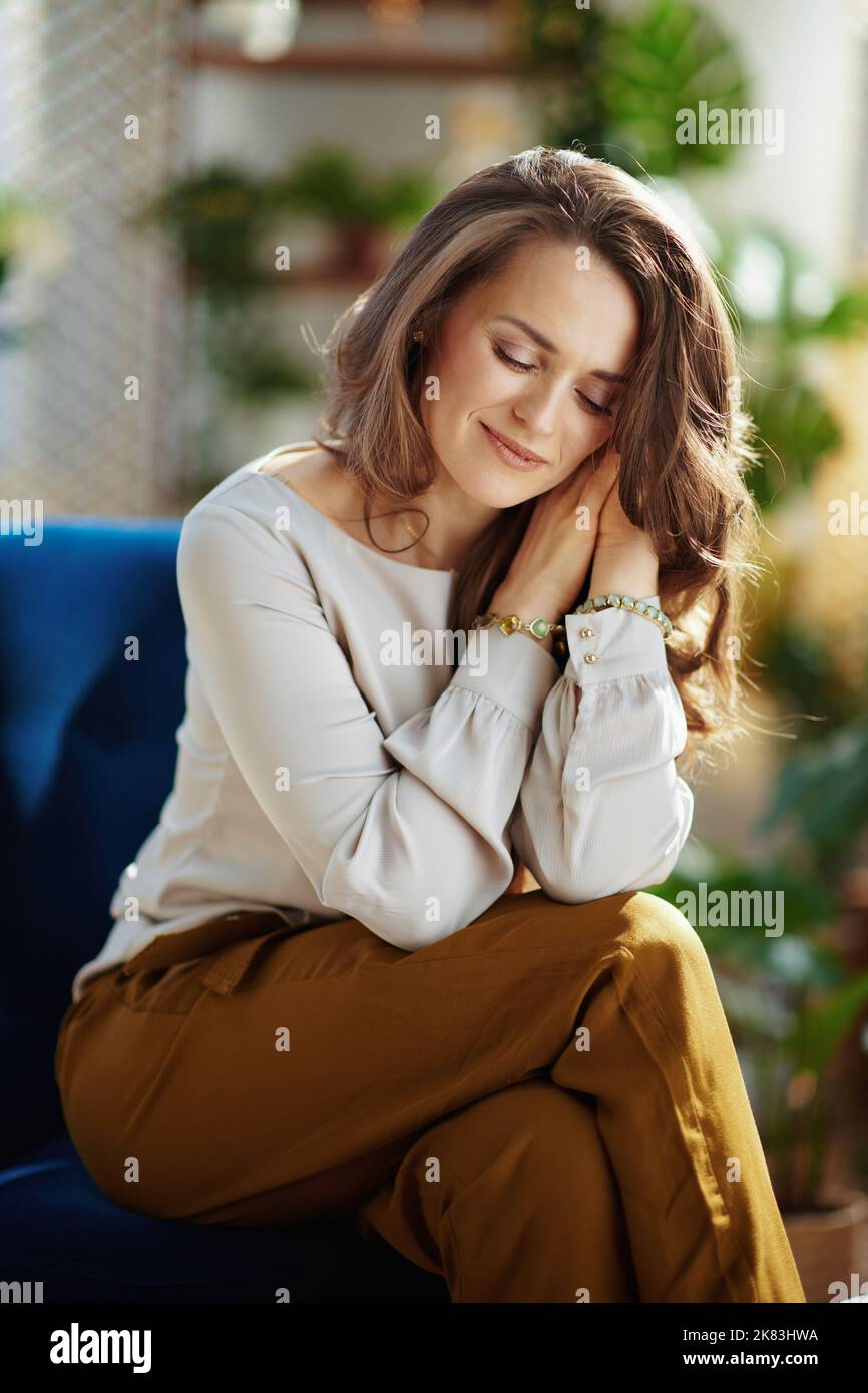 Green Home. relaxed modern woman with long wavy hair in the modern ...