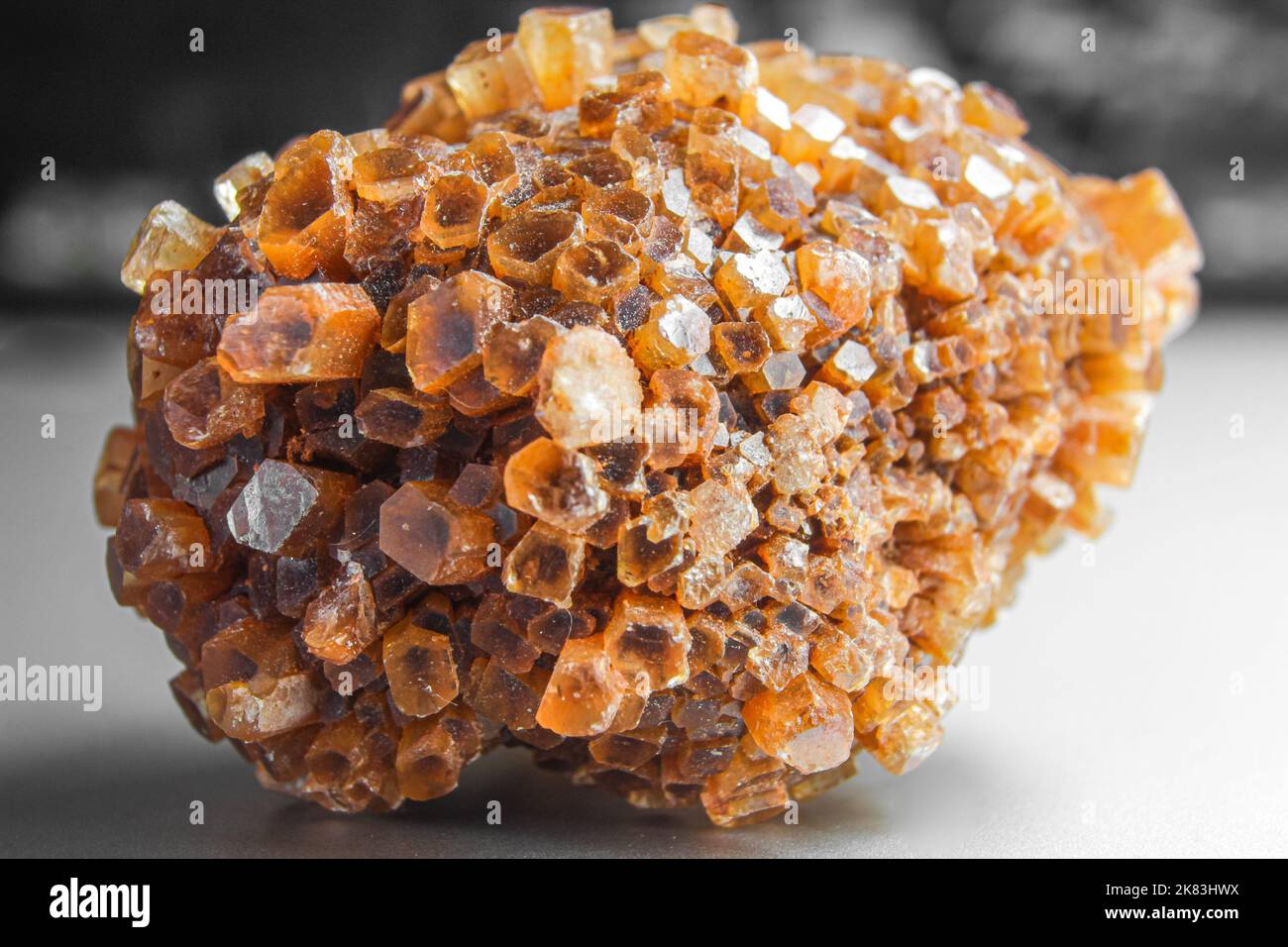 Aragonite cluster, orange crystal on top of the silver surface. Macro ...