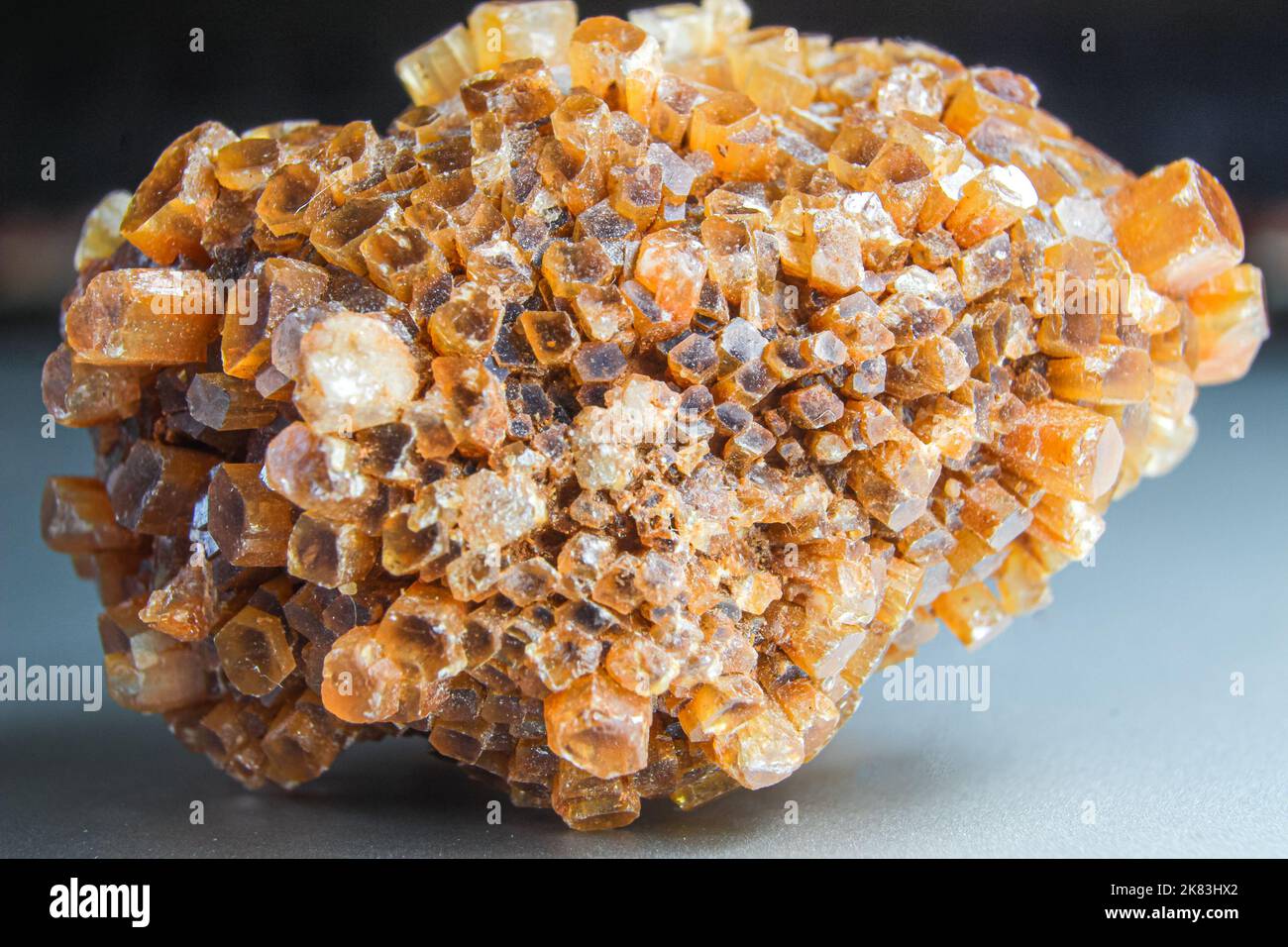 Aragonite cluster, orange crystal on top of the silver surface. Macro ...