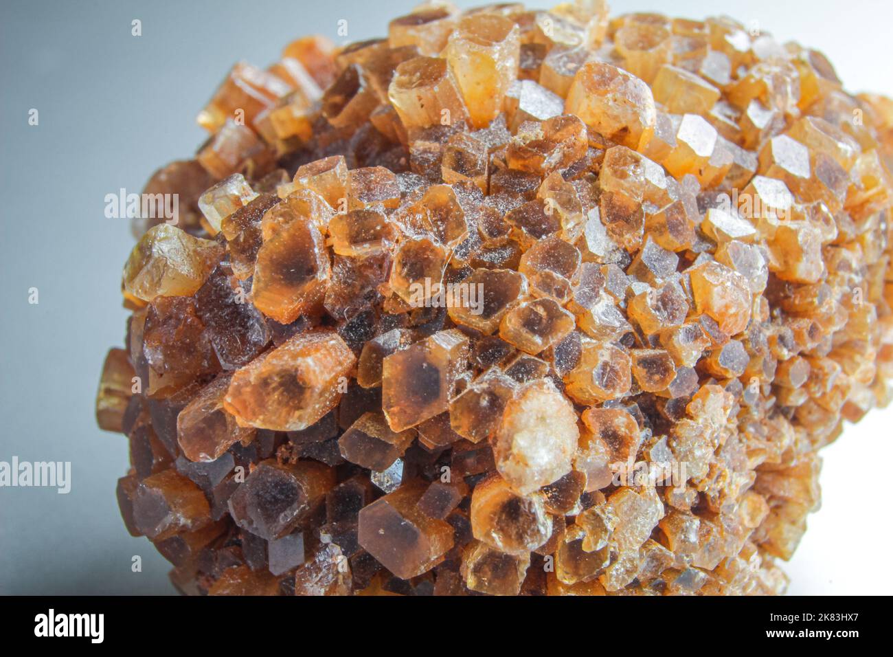 Aragonite cluster, orange crystal on top of the silver surface. Macro ...