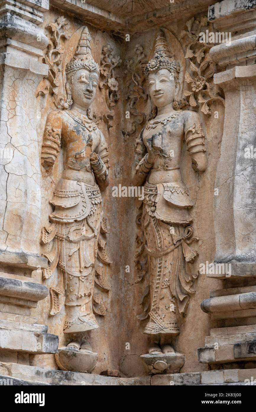 Ancient stucco carving life size deities on wall of historic Wat Chet ...
