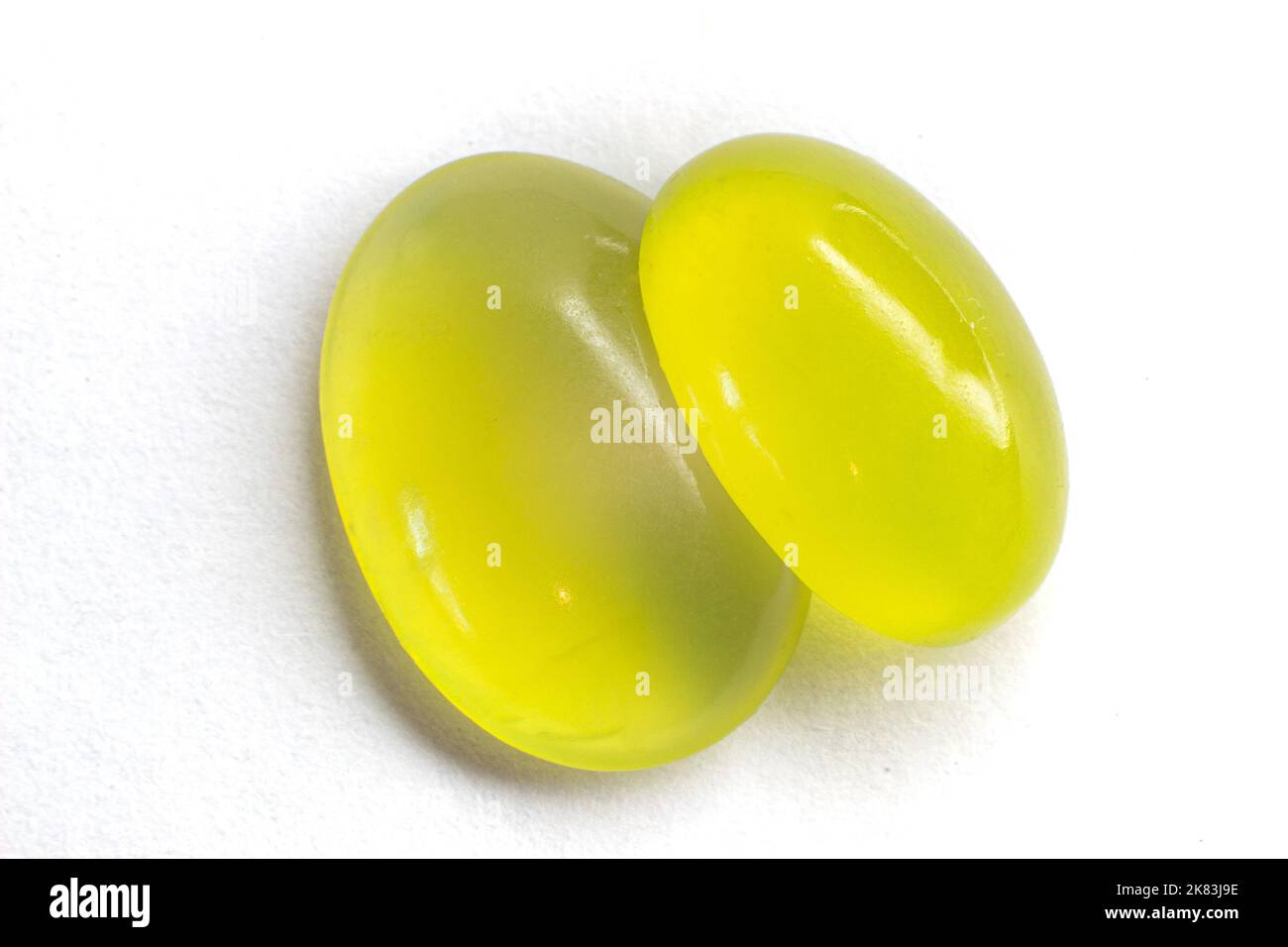 Two Peridots on top of each other on a white background. Olivine oval ...
