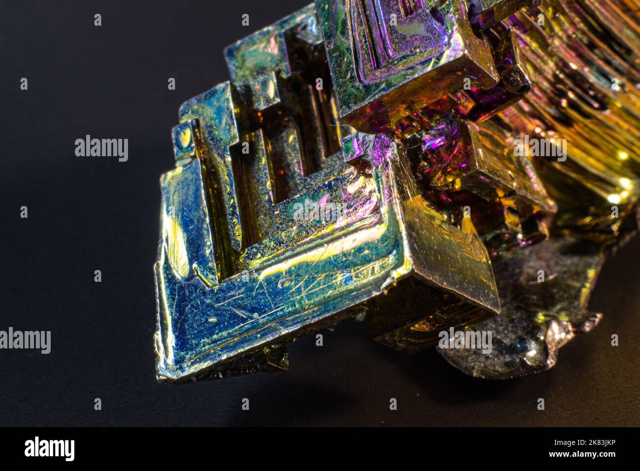 Bismuth bi close up on black surface.Interesting colour and shape ...
