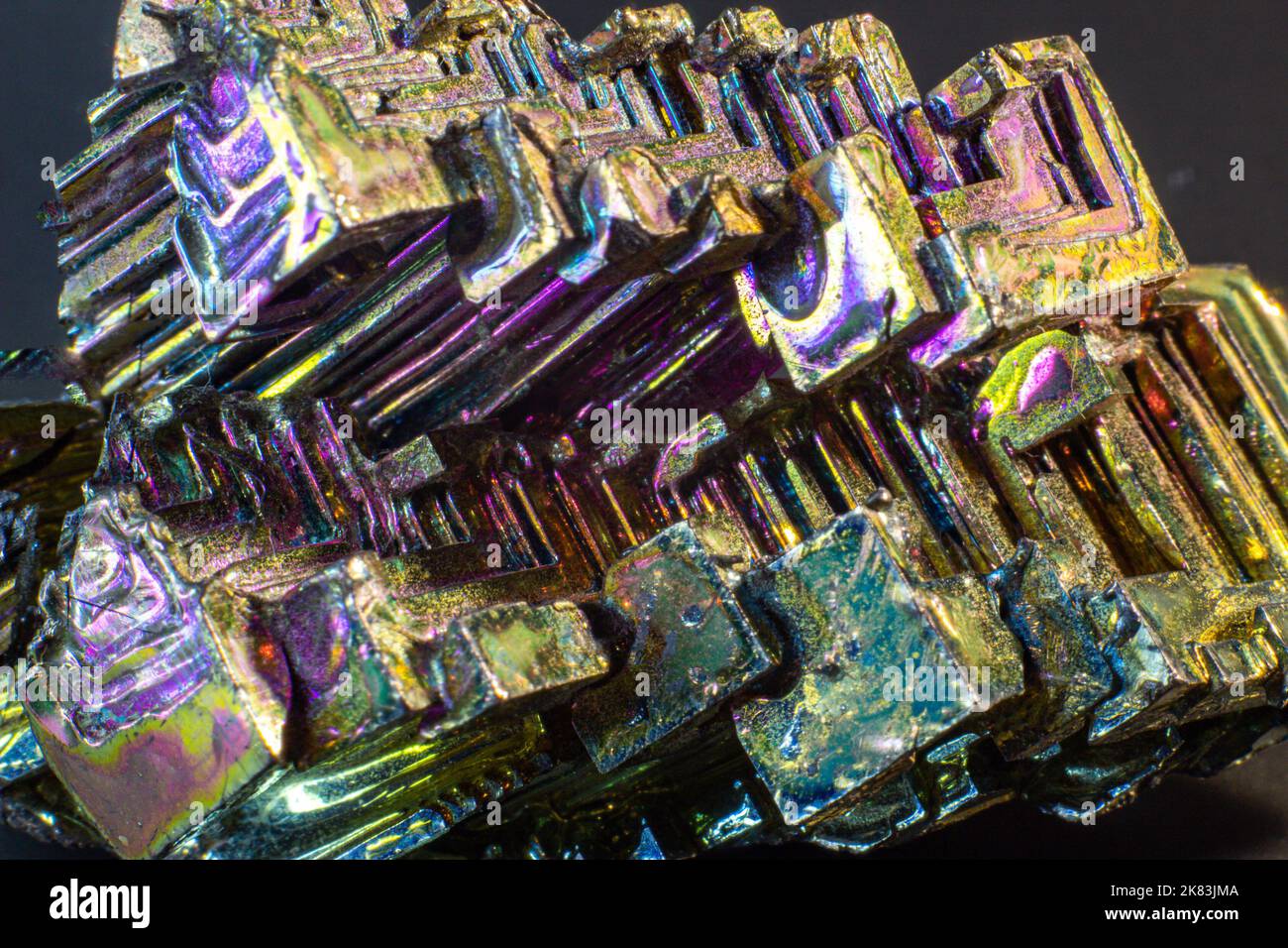 Bismuth bi close up on black surface.Interesting colour and shape ...