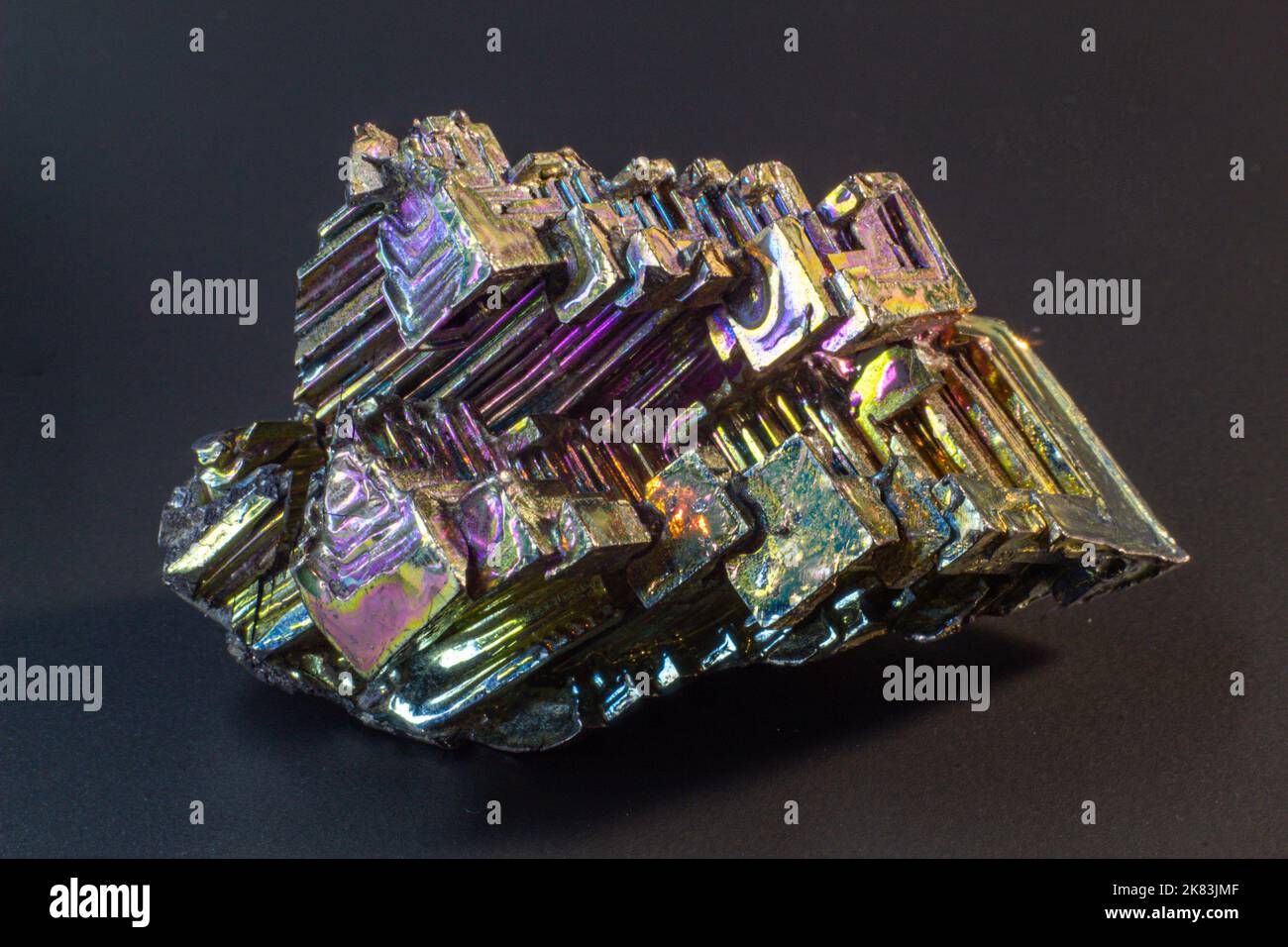Bismuth bi close up on black surface.Interesting colour and shape ...