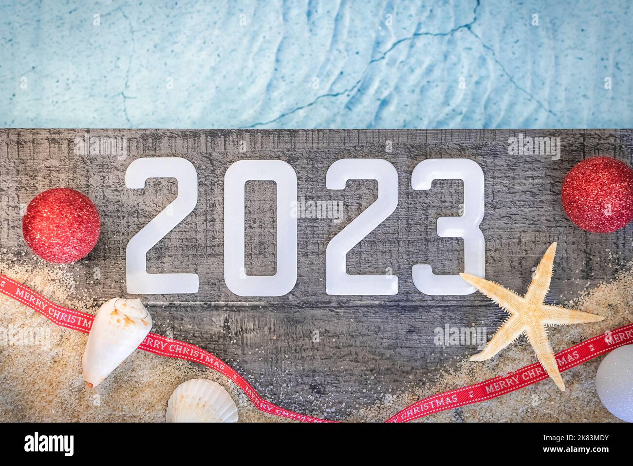 Happy New Year 2023 concept with a shell and a starfish by a pool ...