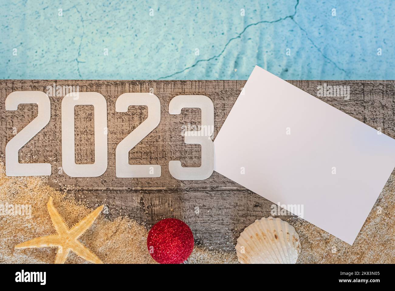 Happy New Year 2023 concept with a shell and a starfish by a pool ...
