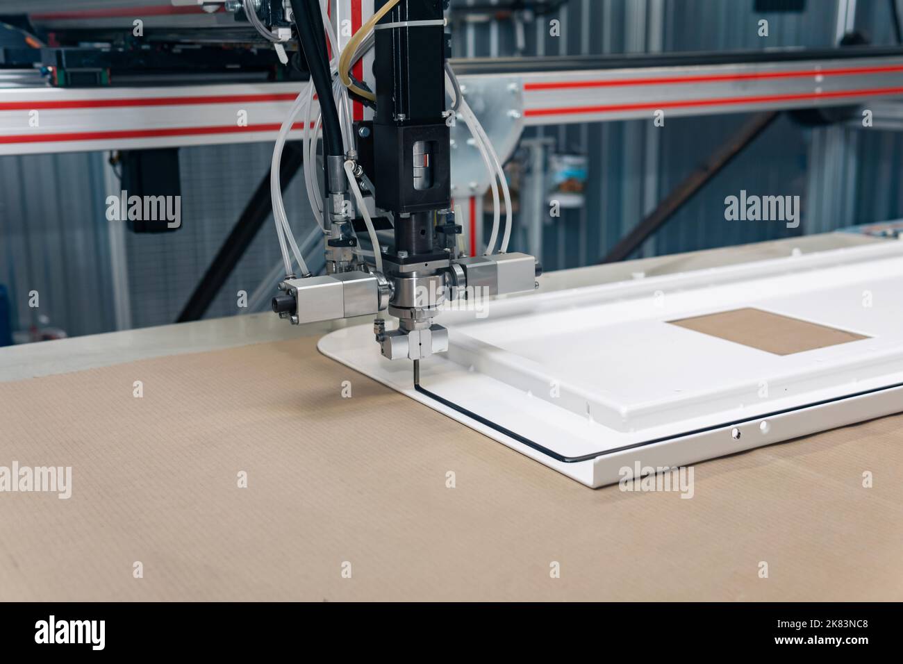 industrial robotic dosing dispenser machine applies a hardening sealant ...