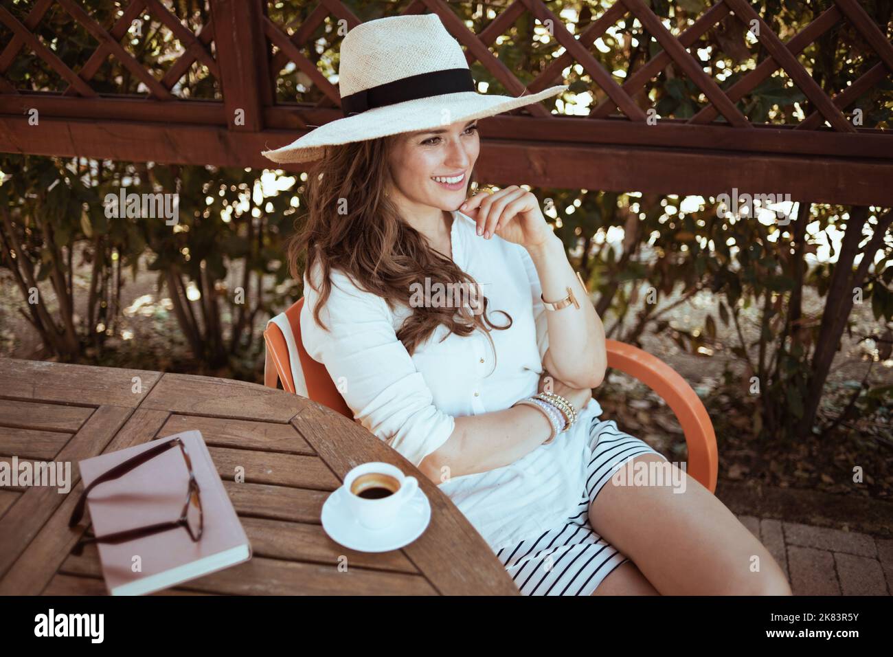 Beautiful woman sitting patio table hi-res stock photography and images ...